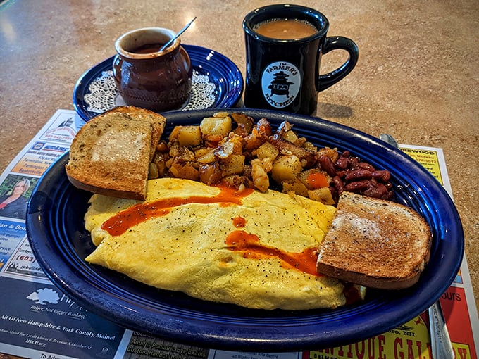 This omelet doesn't just sit on the plate—it lounges confidently beside perfectly crisped home fries, with hot sauce adding that "good morning" wake-up call.