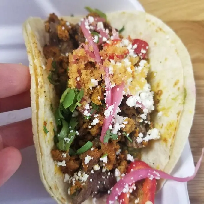 Meat, meet destiny. The perfect distribution of protein, garnish, and cheese creates the holy trinity of taco architecture.