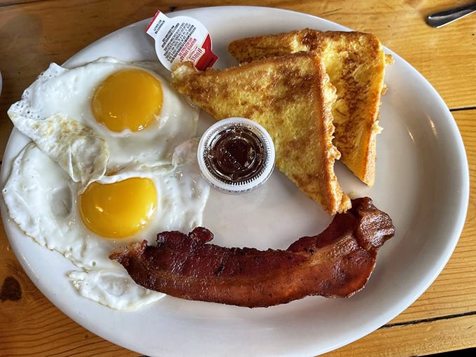Two sunny-side up eggs flanking crispy bacon and golden toast—the breakfast equivalent of a perfect high five to start your day right.