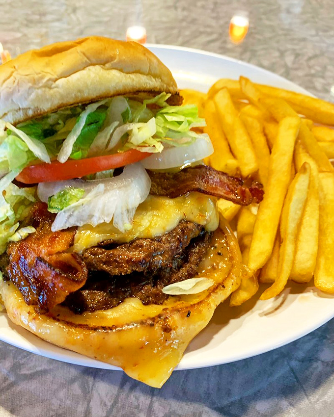 This isn't just a burger – it's a masterpiece of melty cheese, crisp bacon, and fresh toppings that requires both hands and several napkins.
