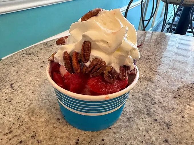These aren't just strawberries—they're summer's heart, captured and preserved beneath a cloud of real whipped cream and tucked beside pecans that add the perfect crunch.