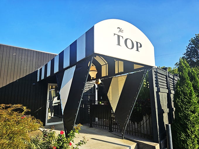 The Top's bold black and white awning announces itself like a tuxedo at a backyard barbecue—classic and unforgettable.