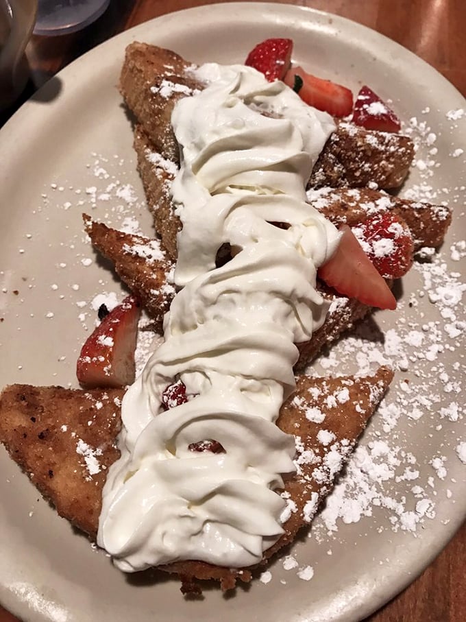 This isn't just French toast—it's a sweet revelation with powdered sugar snow and berry accents. Your diet plan's worst nightmare and your taste buds' dream come true.