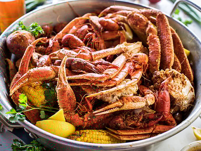 This seafood boil isn't just dinner—it's an event. Crab legs reaching skyward like they're trying to escape their delicious fate.