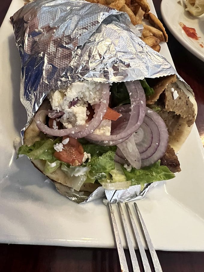 Peek inside this foil-wrapped treasure and discover why locals make pilgrimages here – fresh veggies, feta, and meat in perfect harmony.