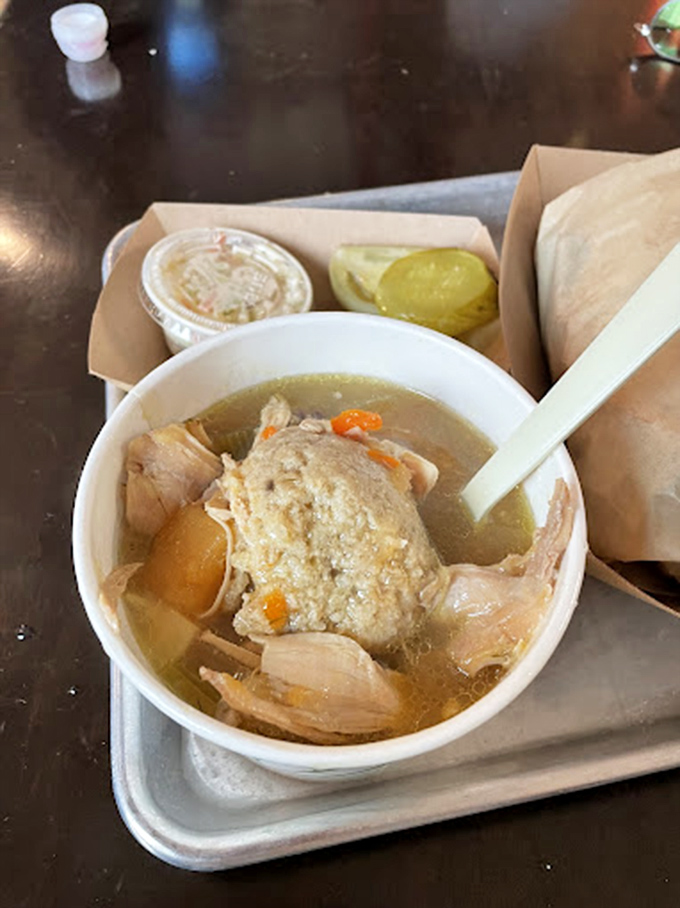 This isn't just soup—it's liquid comfort served alongside what appears to be the world's most perfect pickle, nature's palate cleanser.