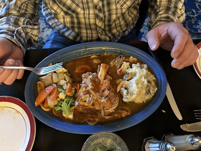 The pork shank doesn't just fall off the bone—it practically jumps onto your fork. Swimming in rich sauce with a side of mashed potatoes for gravy-soaking duty.