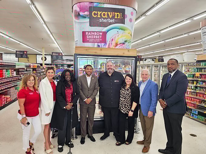 A gathering of what appears to be community members or visitors near the frozen section—grocery shopping as a social experience.