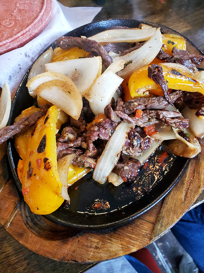 Sizzling steak fajitas that announce their arrival with both sound and aroma—the dinner theater we all deserve.