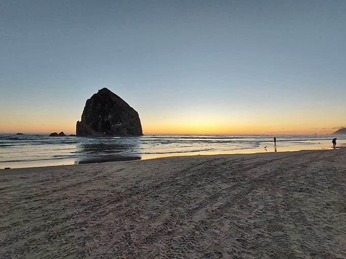 Haystack Rock's lesser-known cousin guards the shoreline at sunset, proving some of life's most magnificent views require no admission fee.