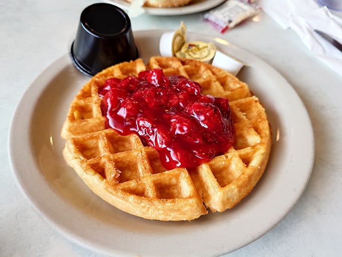 A waffle that doesn't waffle on flavor—golden, crisp, and crowned with ruby-red berries that pop with every bite.