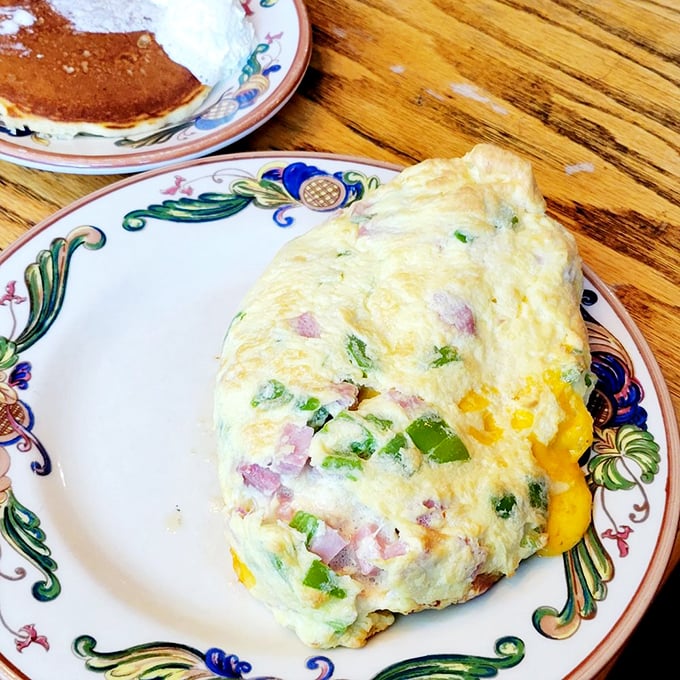 An omelet that's practically bursting with colorful fillings. Like a savory sunrise on a plate, with each bite delivering a perfect balance of egg and ingredients.