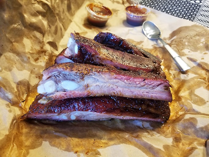 These ribs have the kind of bark that doesn't need a bite—more like a gentle suggestion before the meat willingly parts from the bone.