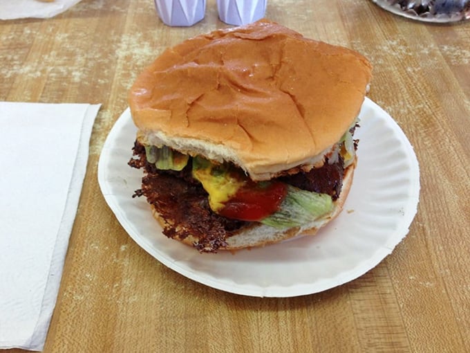 Three patties, cheese melted between each layer—this burger stack isn't just lunch, it's an engineering marvel with a side of nostalgia.