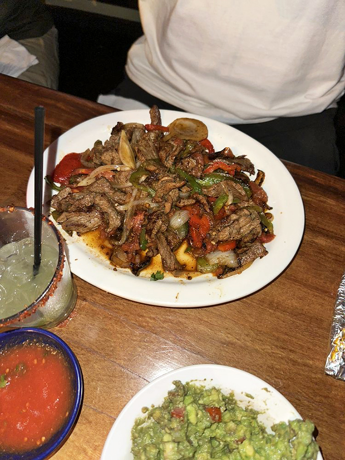 This sizzling beef fajita platter doesn't just arrive at your table—it makes an entrance, with peppers and onions still performing their delicious dance.