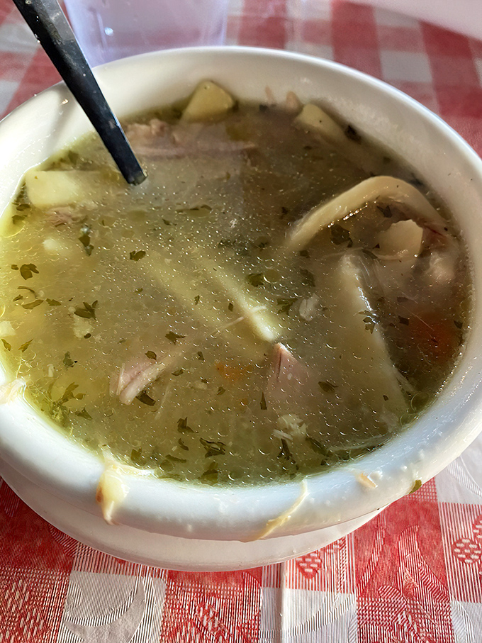 This chicken noodle soup isn't medicine—it's time travel in a bowl, with hearty noodles and chunks of chicken swimming in liquid comfort.
