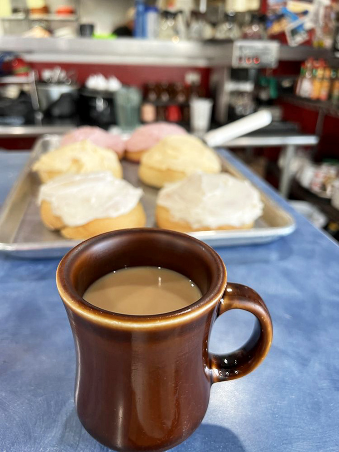 That perfect diner coffee moment—brown ceramic mug, fresh pastries in the background. Some mornings need nothing more.