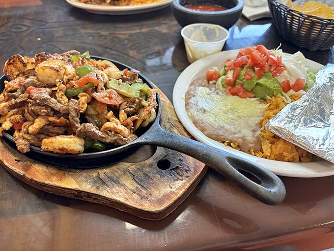 The sizzle announces their arrival before you see them—fajitas that perform a symphony of steam and spice tableside.