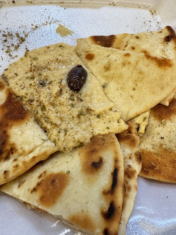 Pita triangles surrounding hummus like worshippers at an altar. The char marks are like flavor freckles—beautiful imperfections that add character.