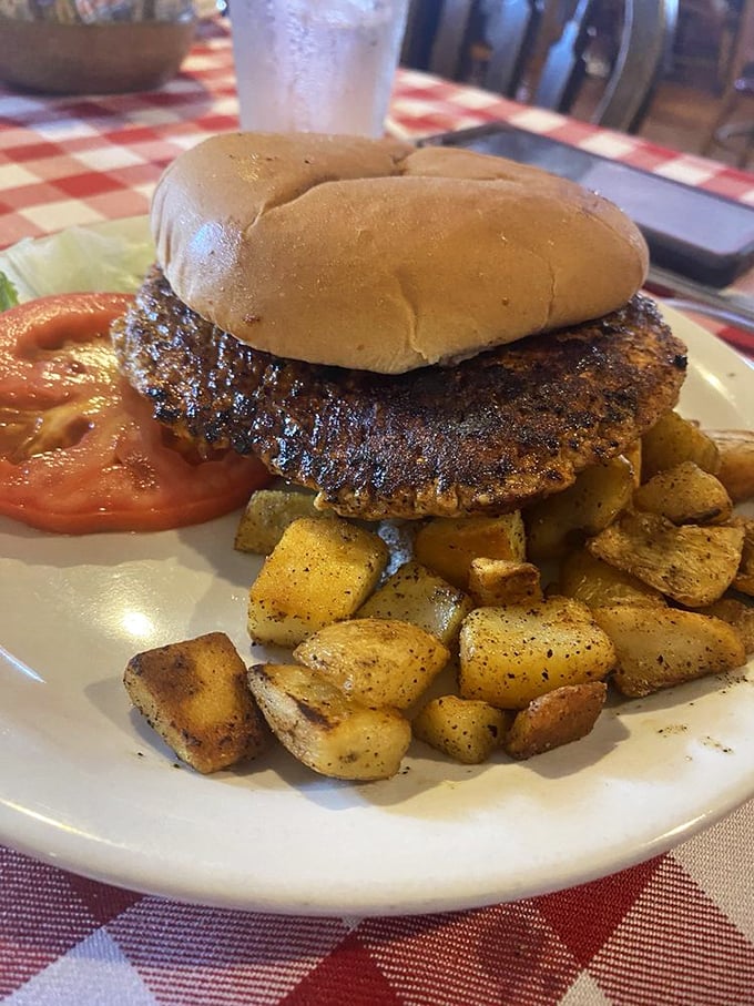 The pork tenderloin sandwich at Herman's doesn't need height to impress – it relies on flavor, like the Danny DeVito of sandwiches.