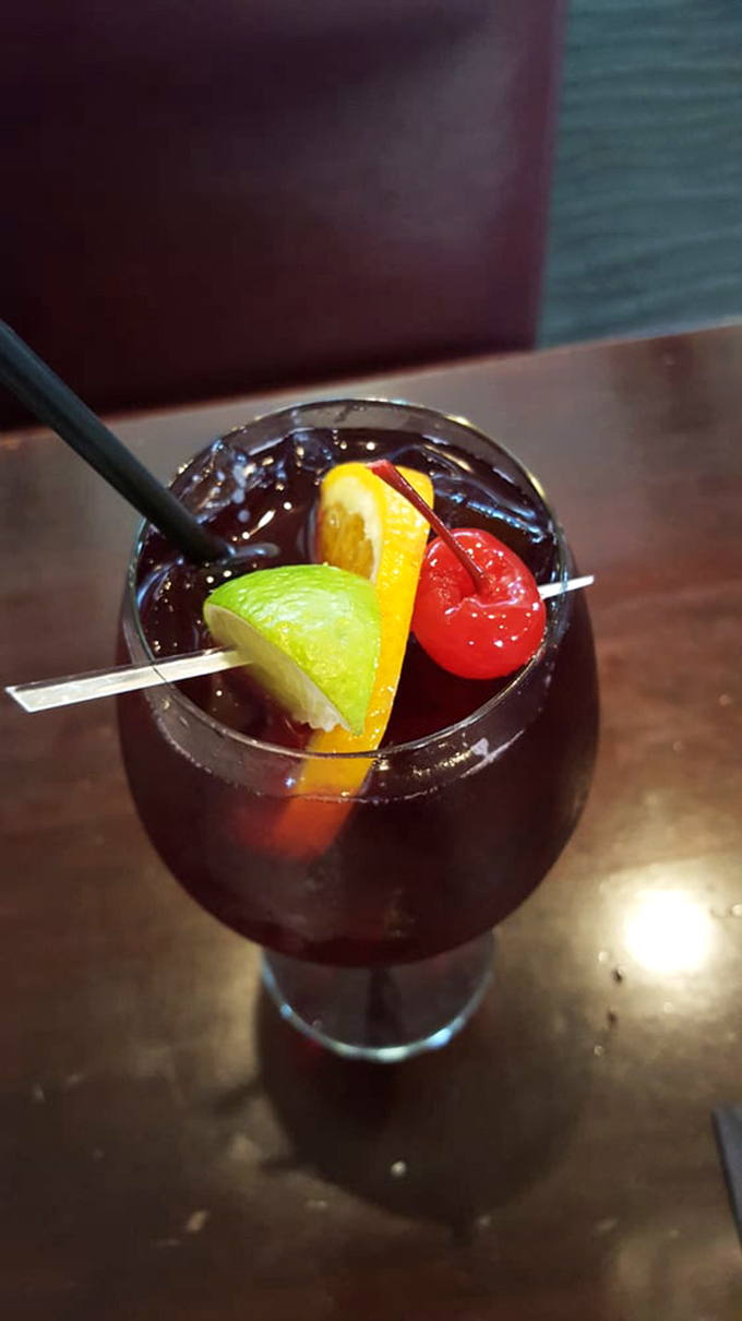 Not just a sangria, but a sunset in a glass. Those fruit garnishes aren't decoration—they're soaking up deliciousness for your finale.