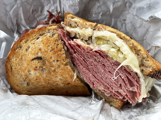 The Reuben in all its glory – a skyscraper of corned beef, sauerkraut, and melted Swiss that requires both hands and zero shame.