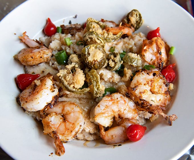Shrimp and grits elevated to an art form. Those plump shrimp lounging on creamy grits with crispy jalapeños are having a party you want to join.