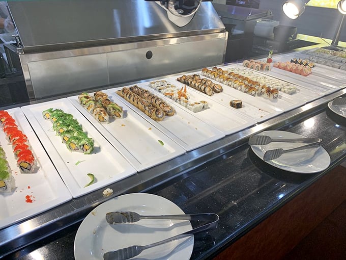 Sushi rolls lined up like colorful soldiers, their fresh ingredients standing at attention while silently daring you to try just one more despite your already full plate.