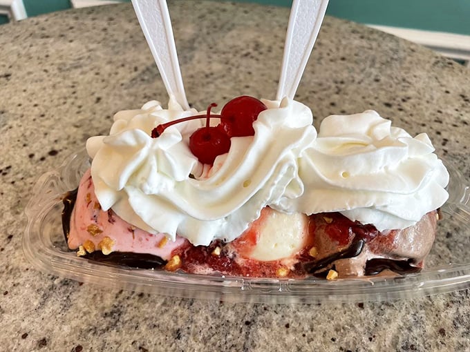 This banana split isn't just dessert, it's architecture—a foundation of fruit supporting multiple neighborhoods of flavor, all under a blanket of cloud-like cream.