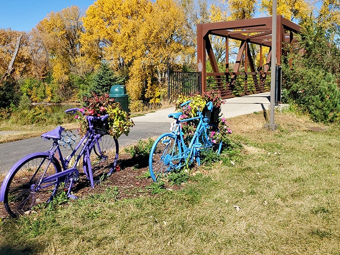 The bike trail entrance looks like the gateway to a Wes Anderson film set – complete with color-coordinated bicycles that seem to be waiting for their cue.