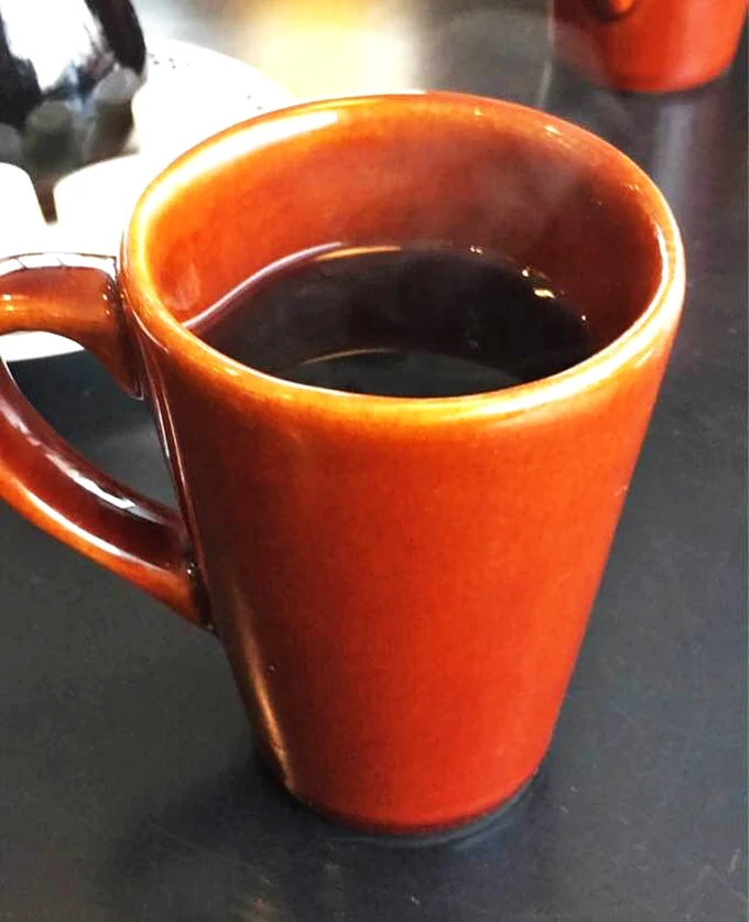 That classic orange diner mug isn't just holding coffee—it's cradling liquid motivation for whatever the day throws at you.