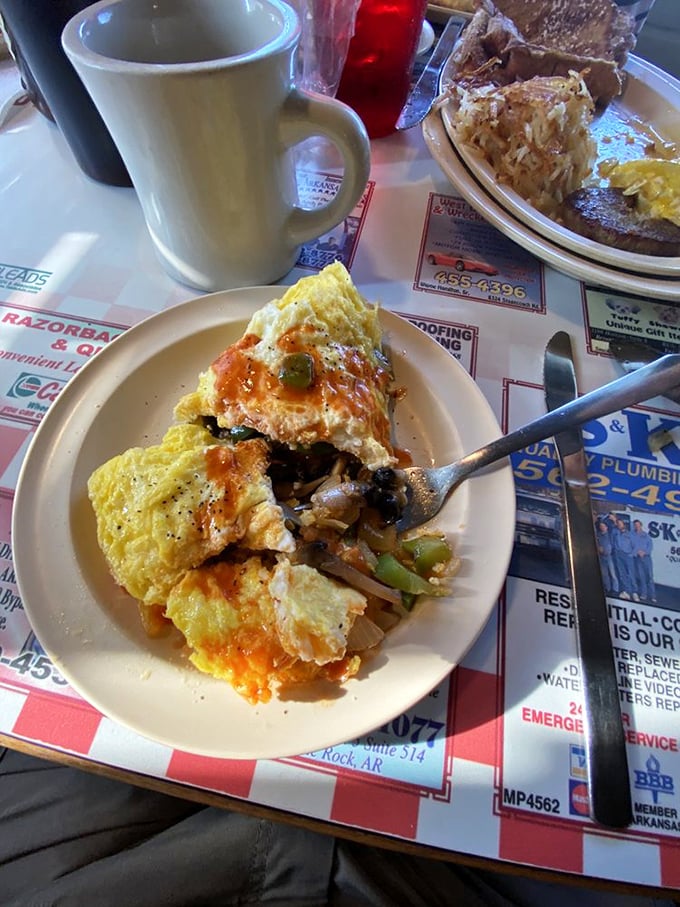 This isn't just an omelet—it's a masterclass in breakfast architecture, with each bite delivering the perfect ratio of egg, filling, and that glorious hot sauce.