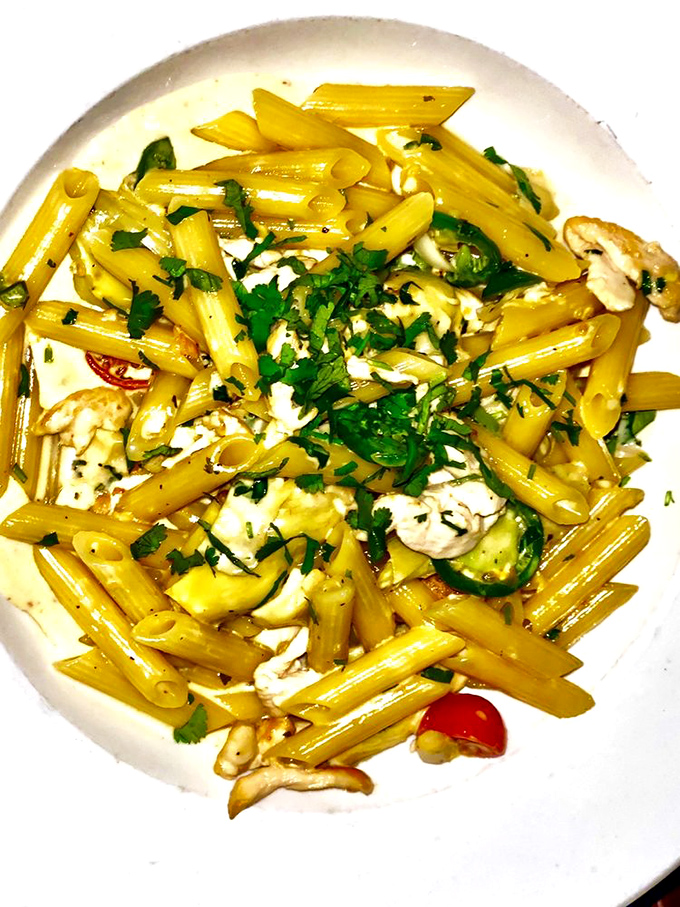 Penne that's been dipped in sunshine. The herbs sprinkled on top aren't just garnish – they're little green flavor bombs waiting to detonate.
