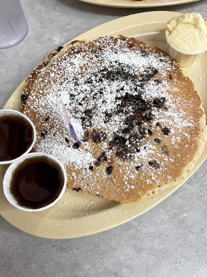 This pancake isn't just big—it's the size of a hubcap, dusted with powdered sugar and studded with chocolate chips like delicious polka dots.