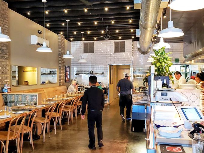 The industrial-chic interior feels like someone converted their pasta workshop into a restaurant and accidentally created perfection.
