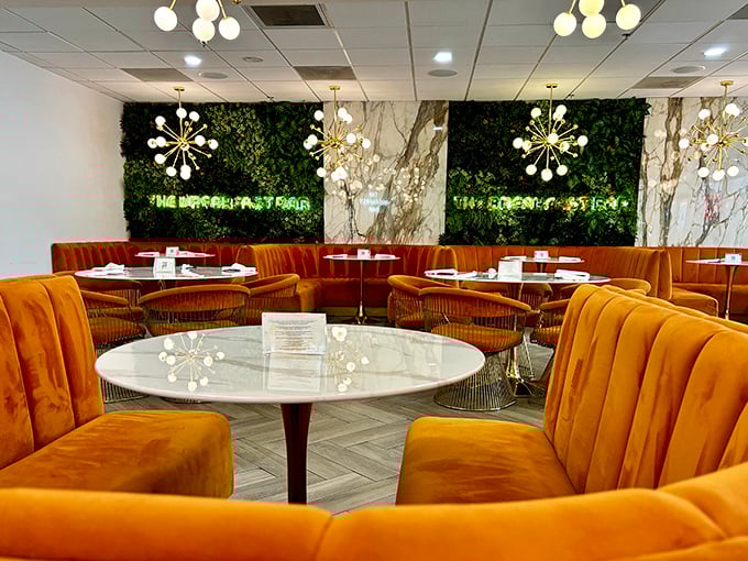 Orange velvet booths and marble tables create a breakfast sanctuary where pancakes taste better and coffee solves more problems.