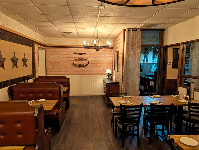 The dining room balances rustic charm with steakhouse sophistication. Those wooden dividers aren't just decorative—they're creating little kingdoms for carnivores.