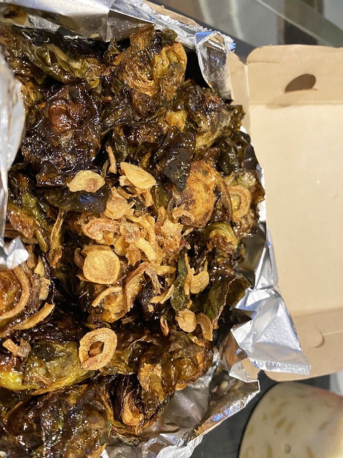 Brussels sprouts transcend their childhood reputation when fried crispy and topped with what appears to be crispy shallots – vegetable redemption at its finest.