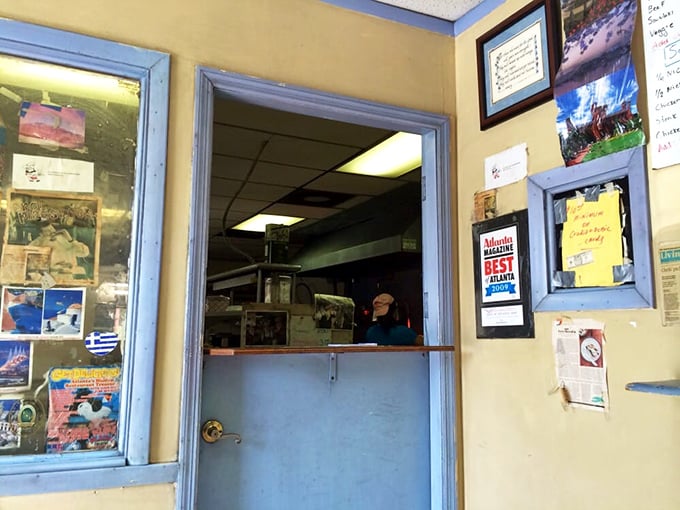 The blue-framed order window—Atlanta's portal to the Mediterranean. Awards on display aren't bragging; they're just confirming what your taste buds are about to discover.