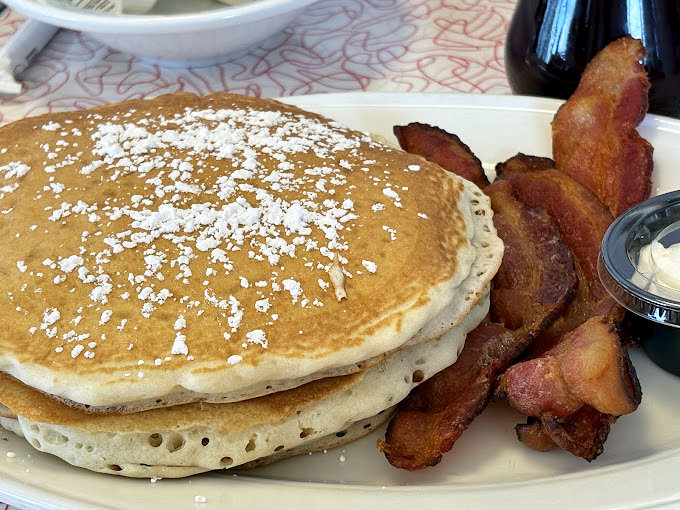 These pancakes have achieved that mythical status: perfectly golden outside, fluffy inside, with just enough powdered sugar to make you feel like you're getting away with something.