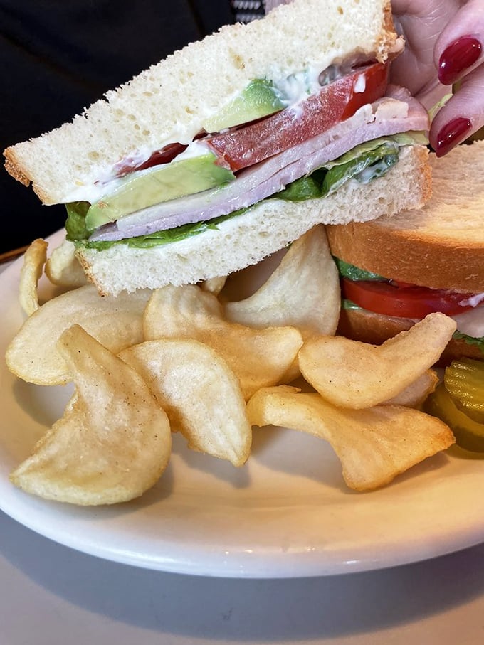This sandwich isn't playing games—layers of fresh ingredients stacked between bread that actually tastes like bread. The potato chips are just showing off.
