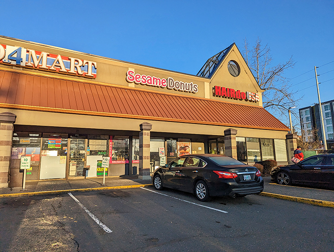 The brick-and-pink exterior is less a building and more a portal to a parallel universe where donuts dare to be different.
