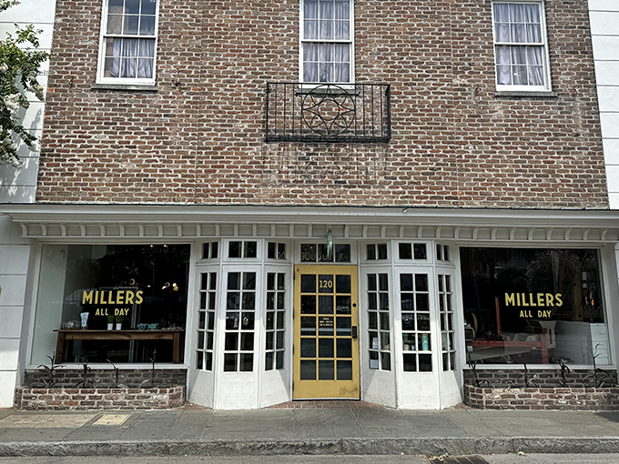 The charming storefront of Millers All Day beckons with its classic brick exterior and cheerful yellow door—like Charleston itself, both elegant and welcoming.