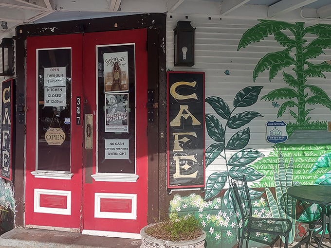 The corner cafe with its iconic red doors and palm tree murals stands like a breakfast beacon in Algiers Point, inviting hungry souls to step inside.