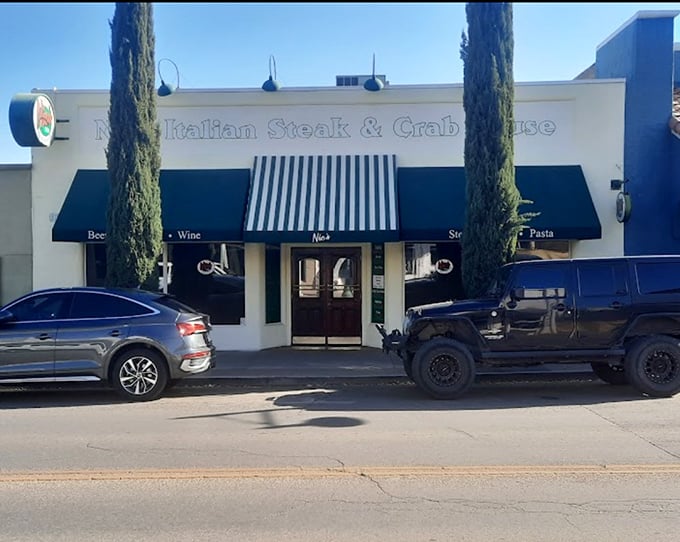 Classic Italian elegance meets small-town Arizona charm at Nic's exterior, where those cypress trees stand like sentinels guarding culinary treasures within.