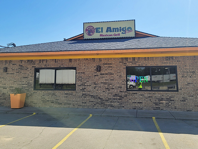 The unassuming brick exterior of El Amigo Feliz stands like a culinary oasis in Hazen, bright orange planters hinting at the vibrant flavors waiting inside.