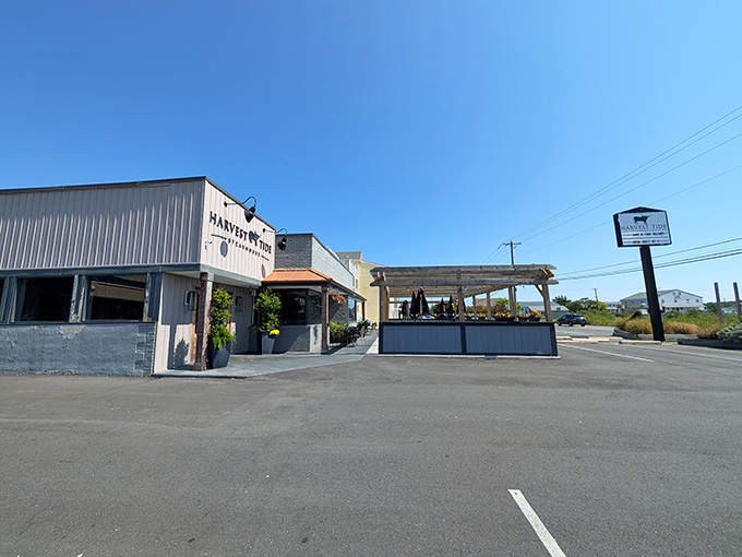 The coastal charm of Harvest Tide's exterior belies the culinary magic happening inside. Gray siding, brick accents, and wooden beams create an inviting first impression.