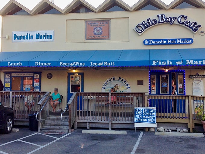 The unassuming entrance to seafood paradise. Olde Bay Café's blue awning and weathered wooden deck promise authentic Florida dining without pretense.