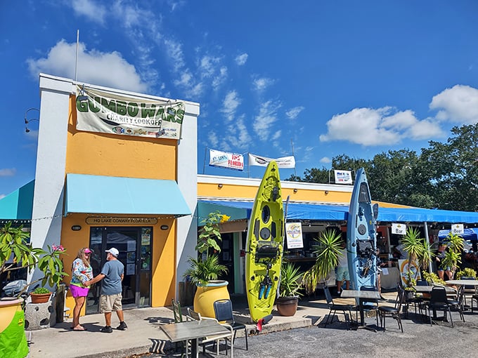 The vibrant yellow exterior of Fish On Fire welcomes seafood lovers with colorful kayaks standing guard, promising Florida flavors without the pretense.