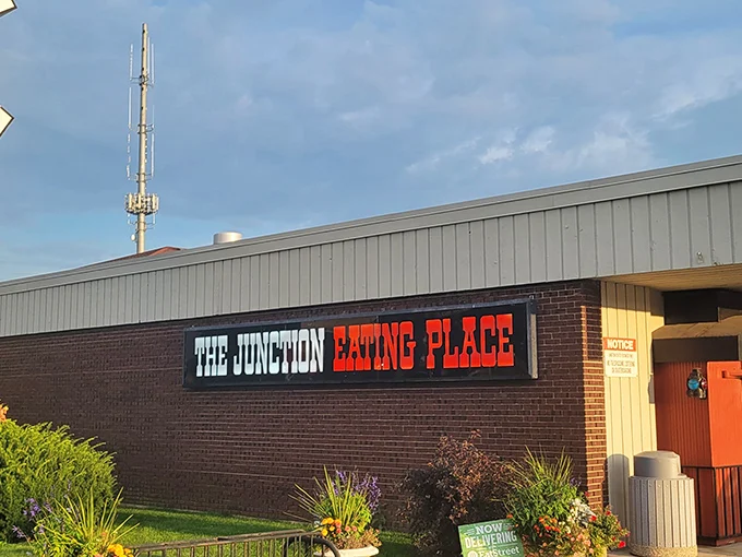 The railroad crossing sign perched atop this unassuming DeKalb diner isn't just decoration—it's a promise of the journey your taste buds are about to take.